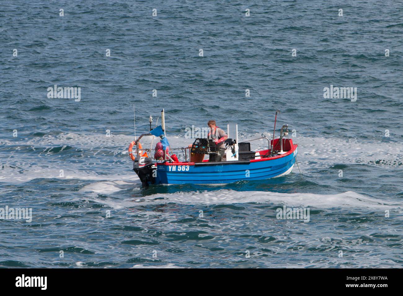 Small open boat with single fisherman setting and pick up crab pots ...