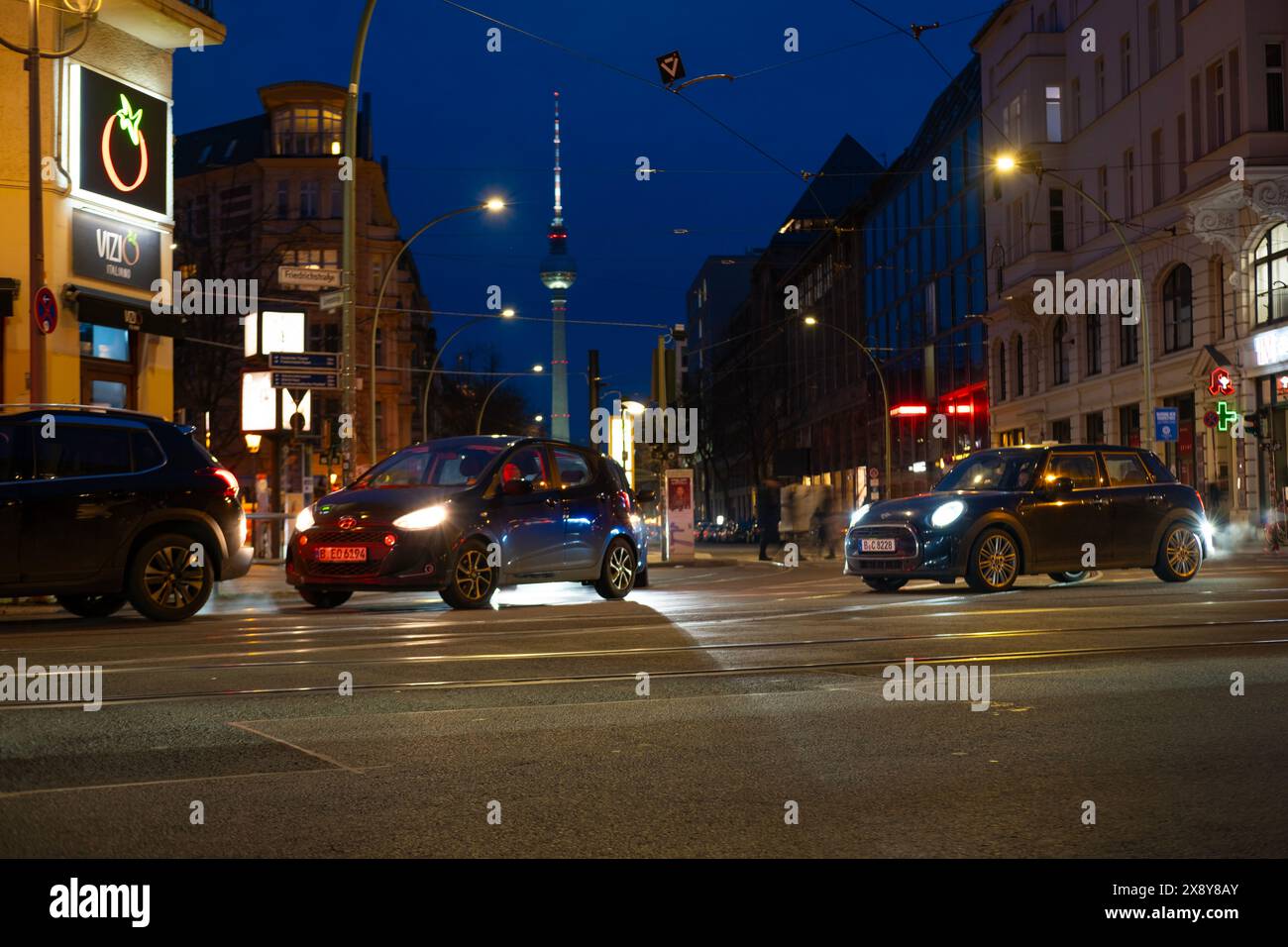 Cars driving down night Oranienburger street, Illuminated buildings and ...