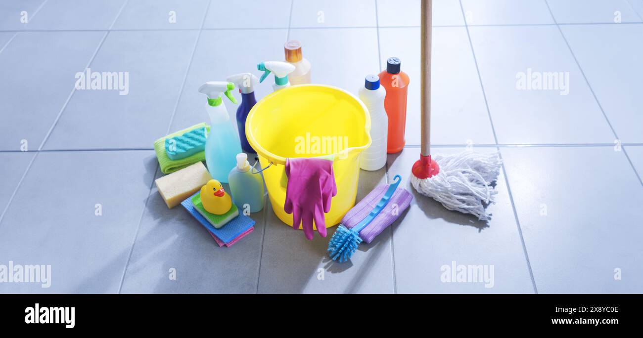 Assorted cleaning supplies and detergents on the bathroom floor ...