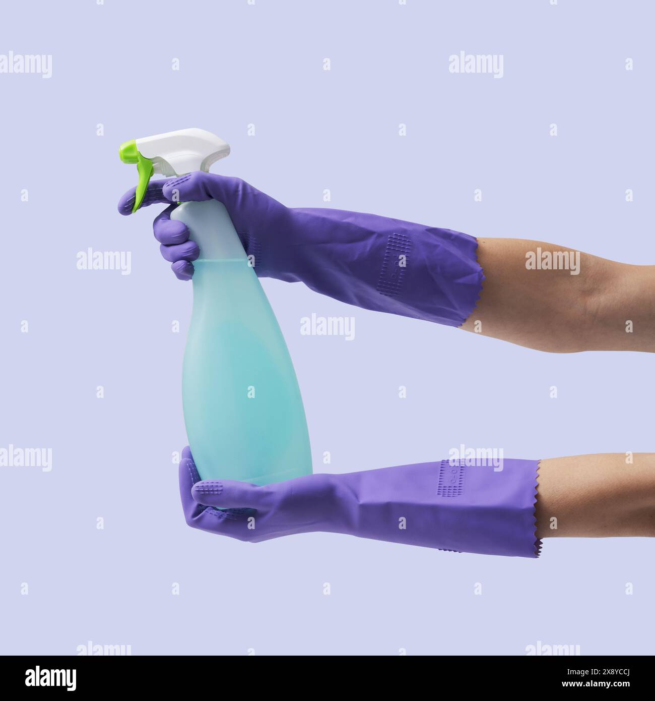 Female hands wearing cleaning gloves and holding a spray detergent ...