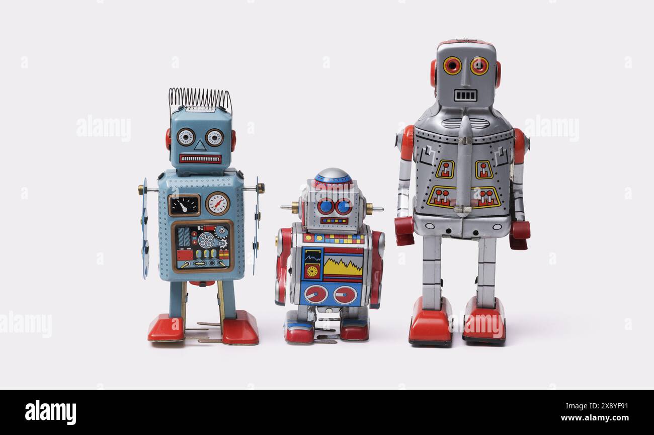 Funny cute tin toy robots standing together on white background Stock ...