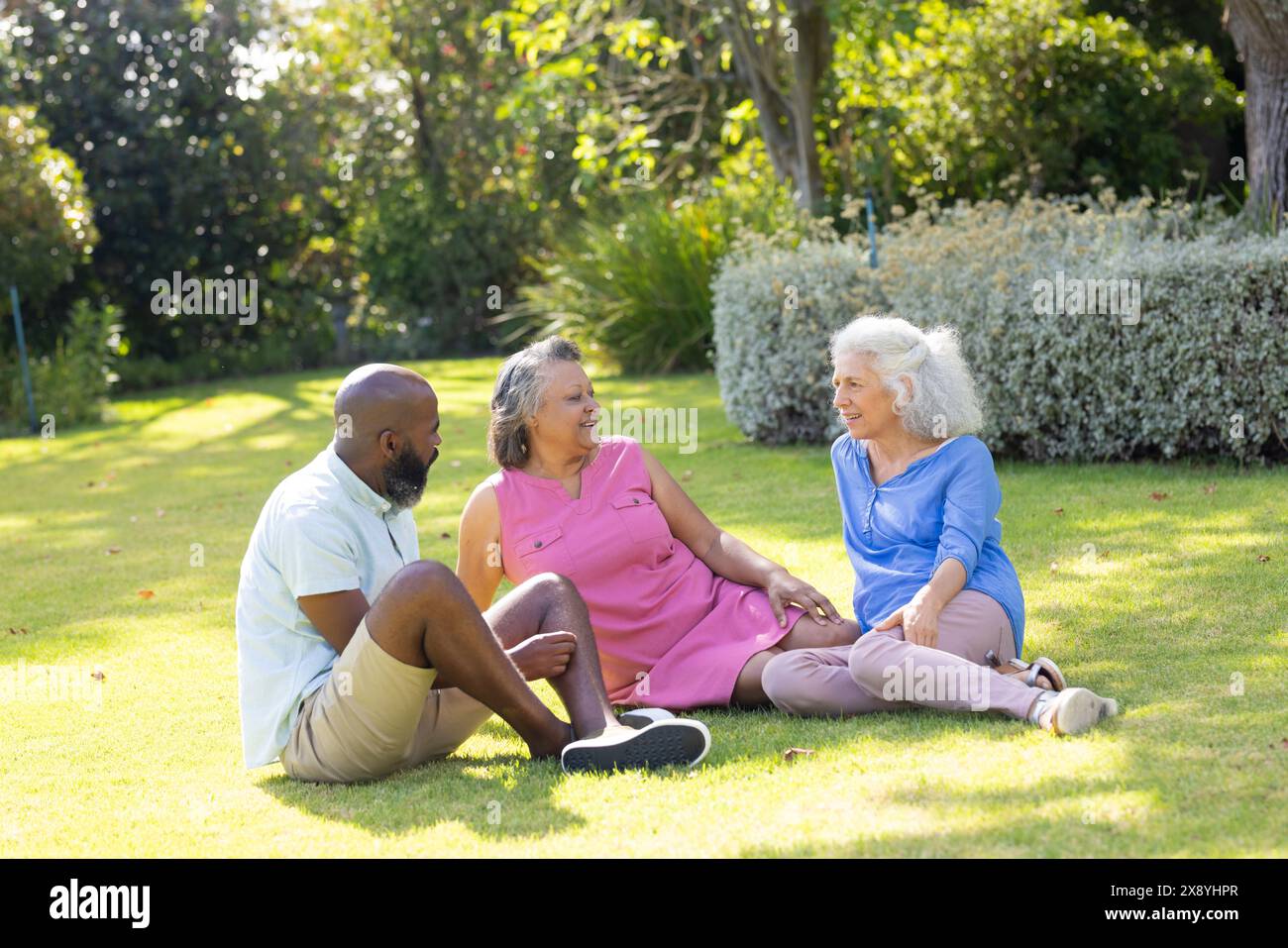 Outdoors, diverse senior friends laughing together in sunny park Stock ...