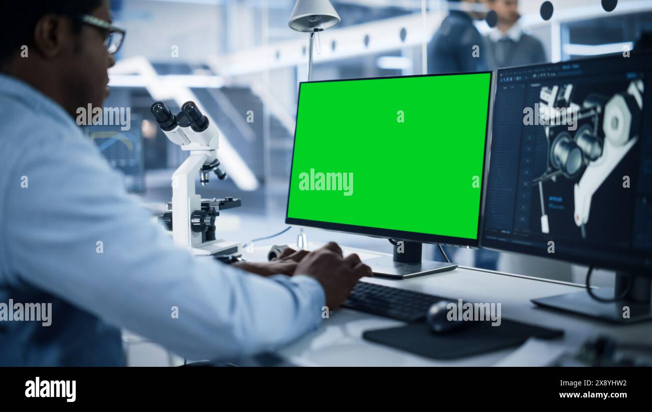 Software Developer Working On Computer With Green Screen Mock Up Display Scientific Lab