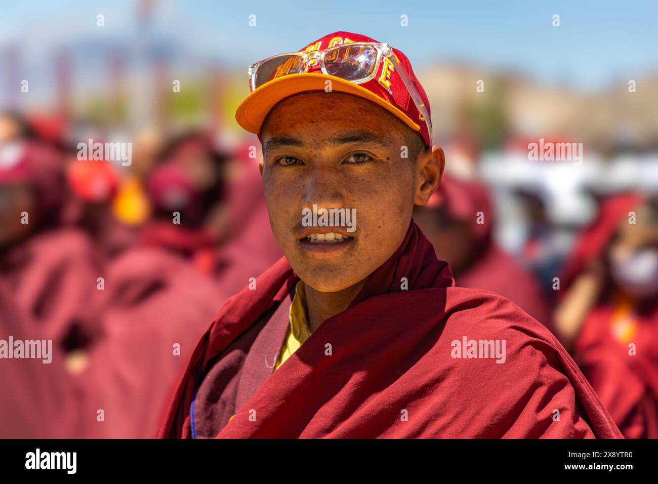 Portrait of a young Buddhist monk from Leh, Ladakh wearing a cap and a ...
