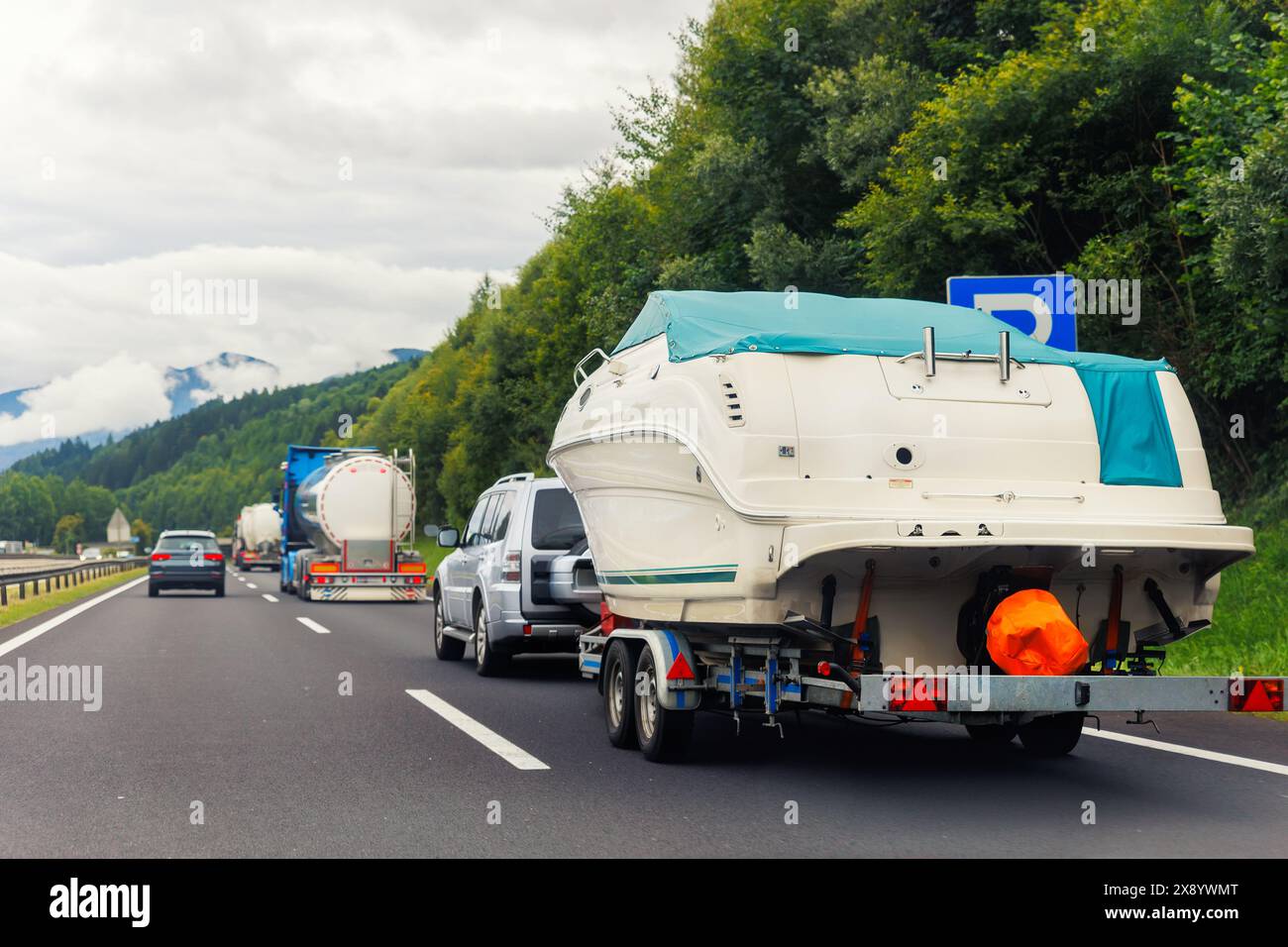 Modern luxury SUV towing yacht boat trailer carrier go river lake sea ...