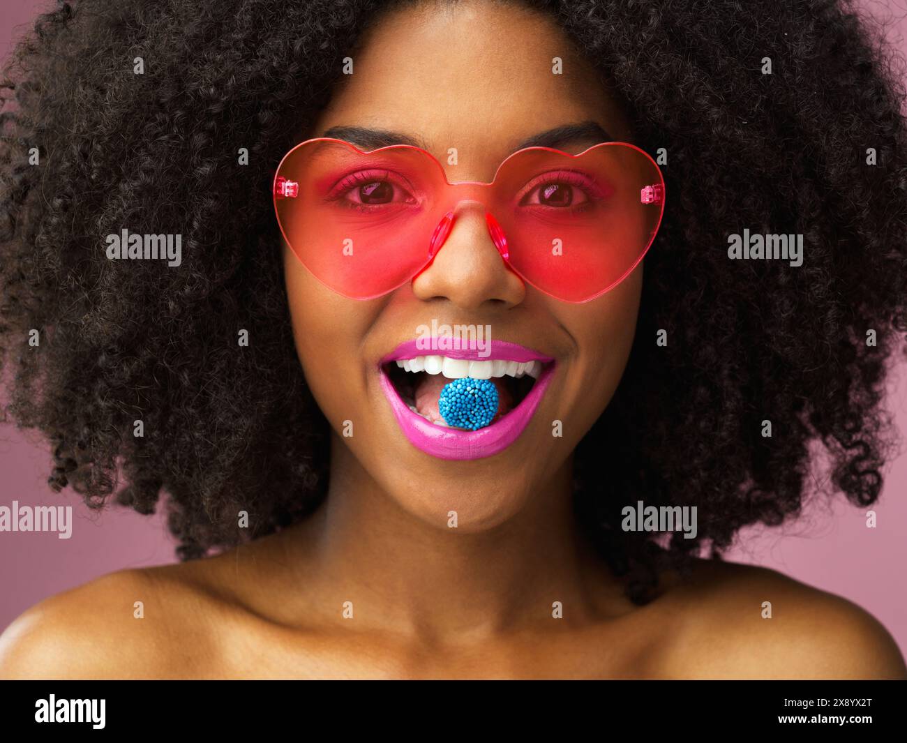 Portrait, candy and woman in studio with retro fashion, heart glasses ...