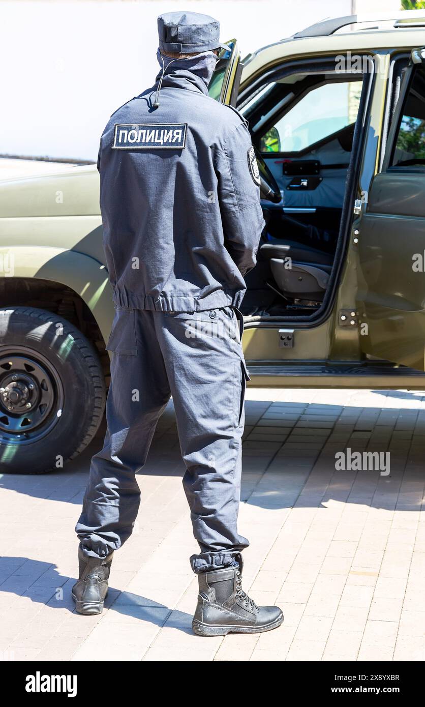 Special Forces police officer in black uniform near a patrol car in ...