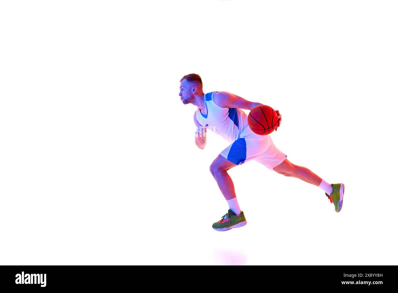 Side view of young, athletic man running in motion to score perfect goal in neon light against ...