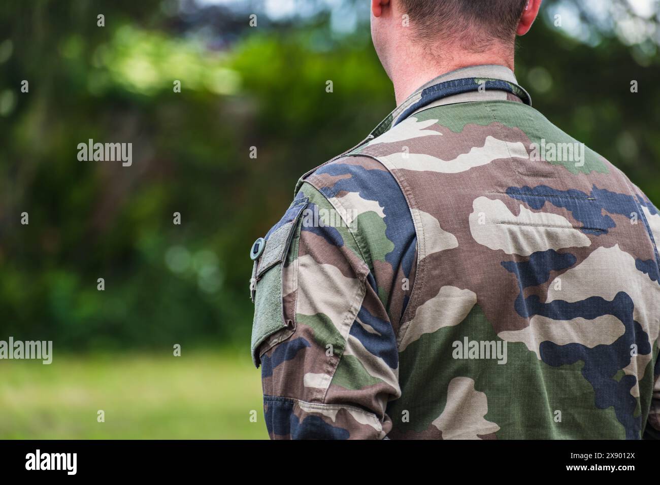 French soldier wearing camouflage uniform, close-up on his back with ...