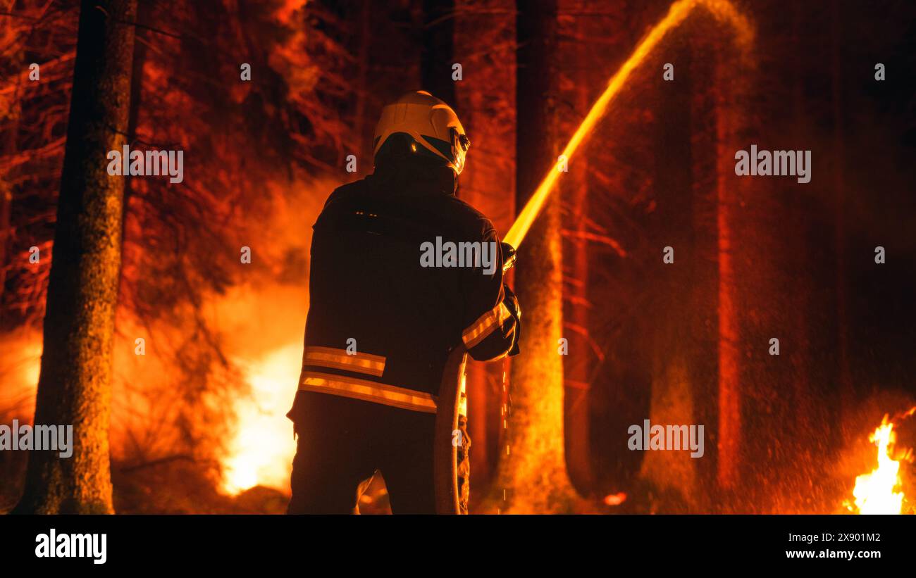 Professional Firefighter Quickly Extinguishing a Forest Fire with the ...
