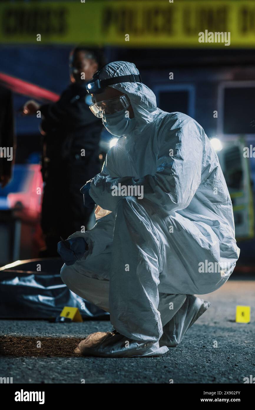 Forensics Expert Observing Clues and Evidence on a Crime Scene at Night ...