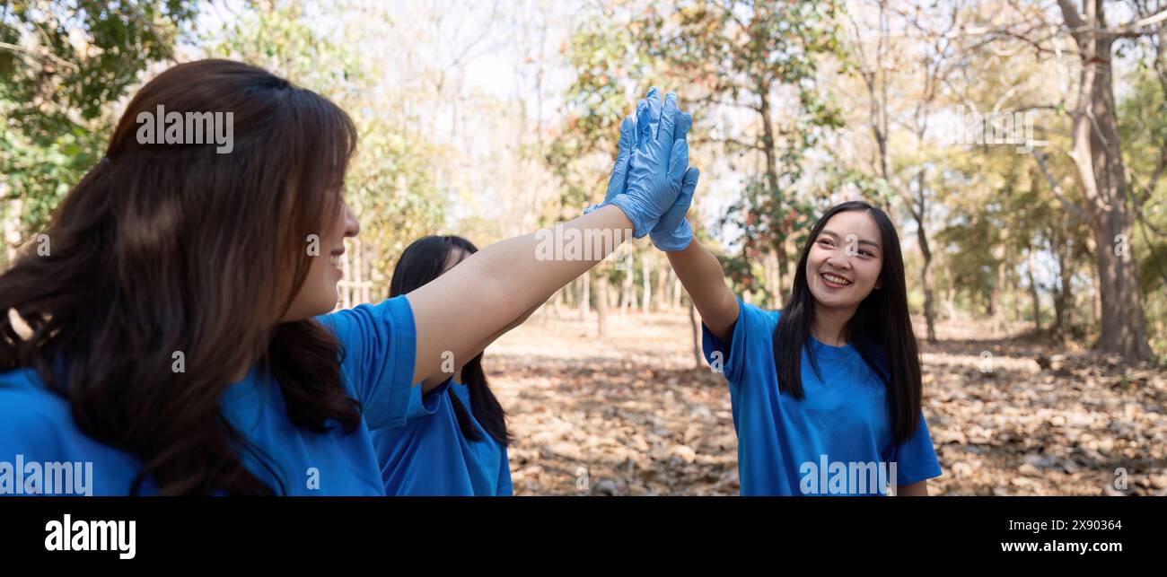 Female volunteer high fiving in forest. Concept of teamwork, unity, and ...