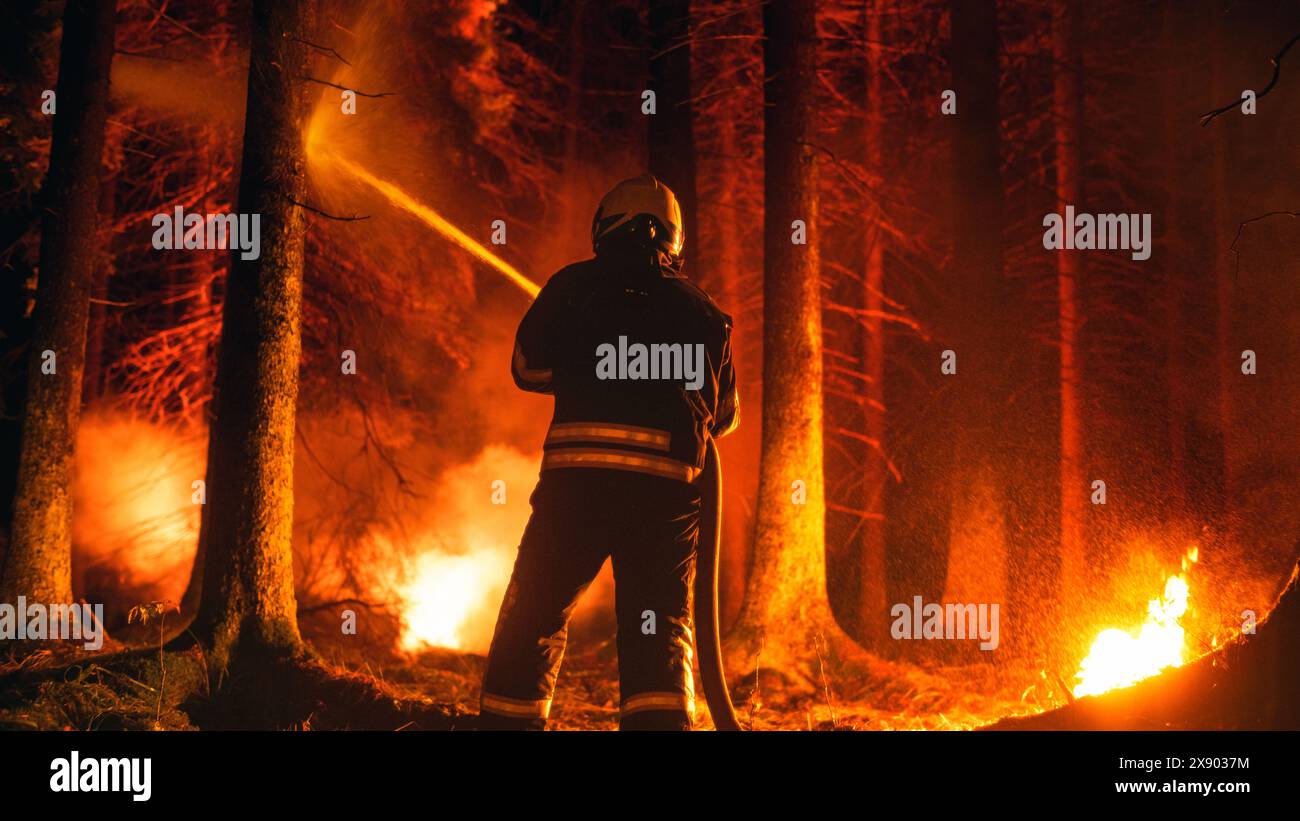 Professional Firefighter Quickly Extinguishing a Forest Fire with the ...