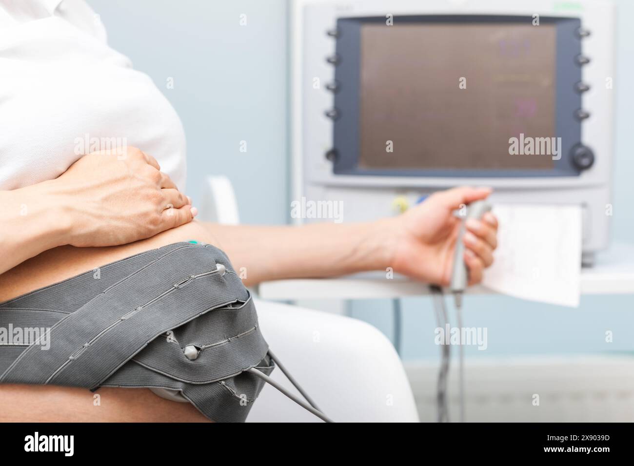 A pregnant woman performing cardiotocography (CTG) to monitor fetal ...