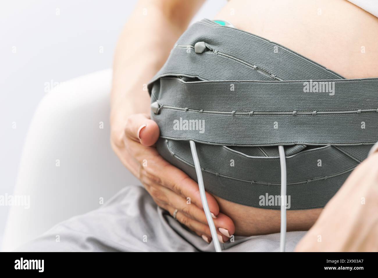 A pregnant woman performing cardiotocography (CTG) to monitor fetal ...