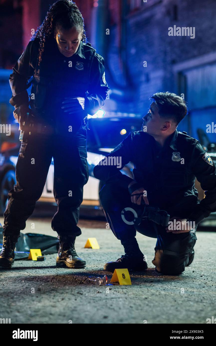 Multiethnic Police Officers Discussing Evidence Found on Crime Scene ...