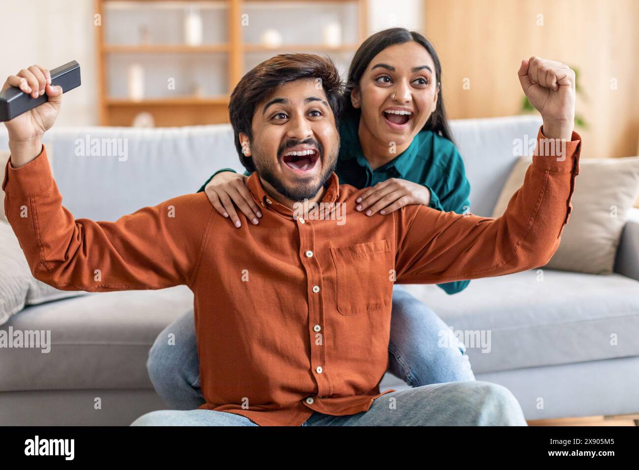 Joyful Couple Celebrates Victory in Living Room During Daytime ...