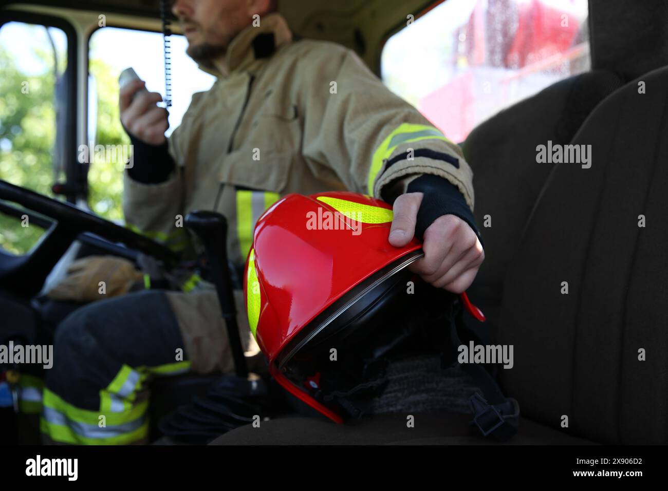 Firefighter using portable radio set while driving fire truck ...