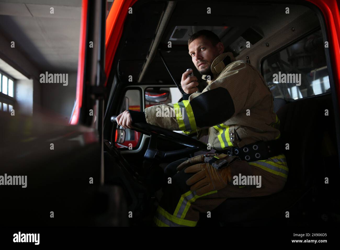 Firefighter using portable radio set while driving fire truck Stock ...