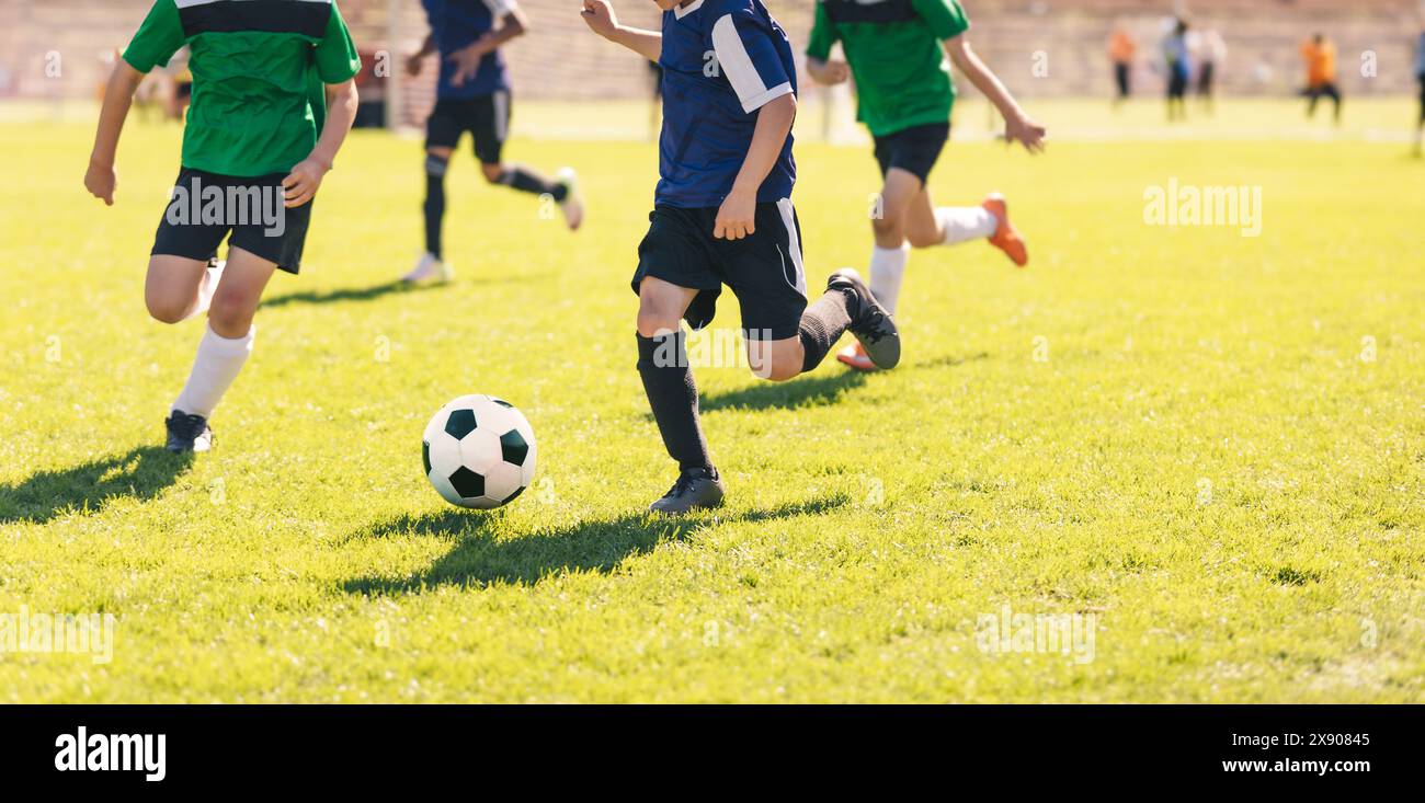 Happy kids compete in football game. Running soccer players ...