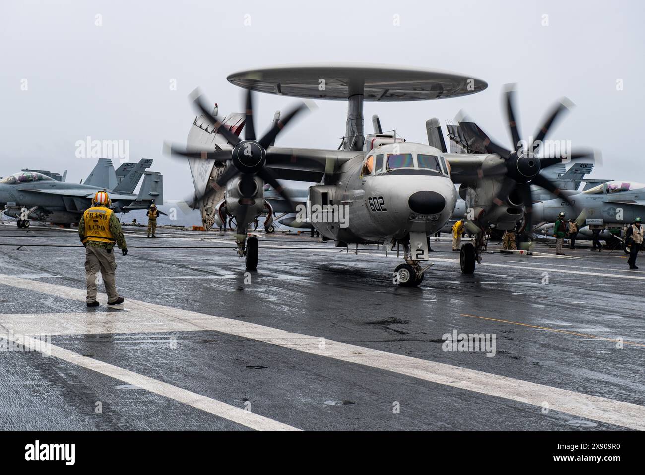 240527-N-SI601-1008 PHILIPPINE SEA (May 27, 2024) Sailors guide an E-2D ...