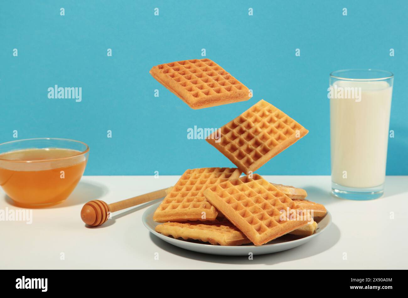 Belgian waffles flying in air on blue and white background. Waffles in ...