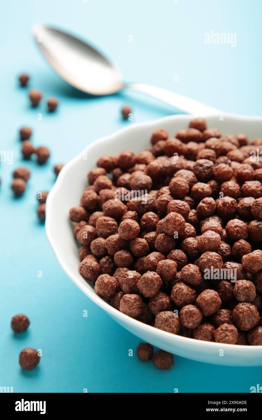 Chocolate cereal corn balls in a blue bowl on a blue background. Top ...
