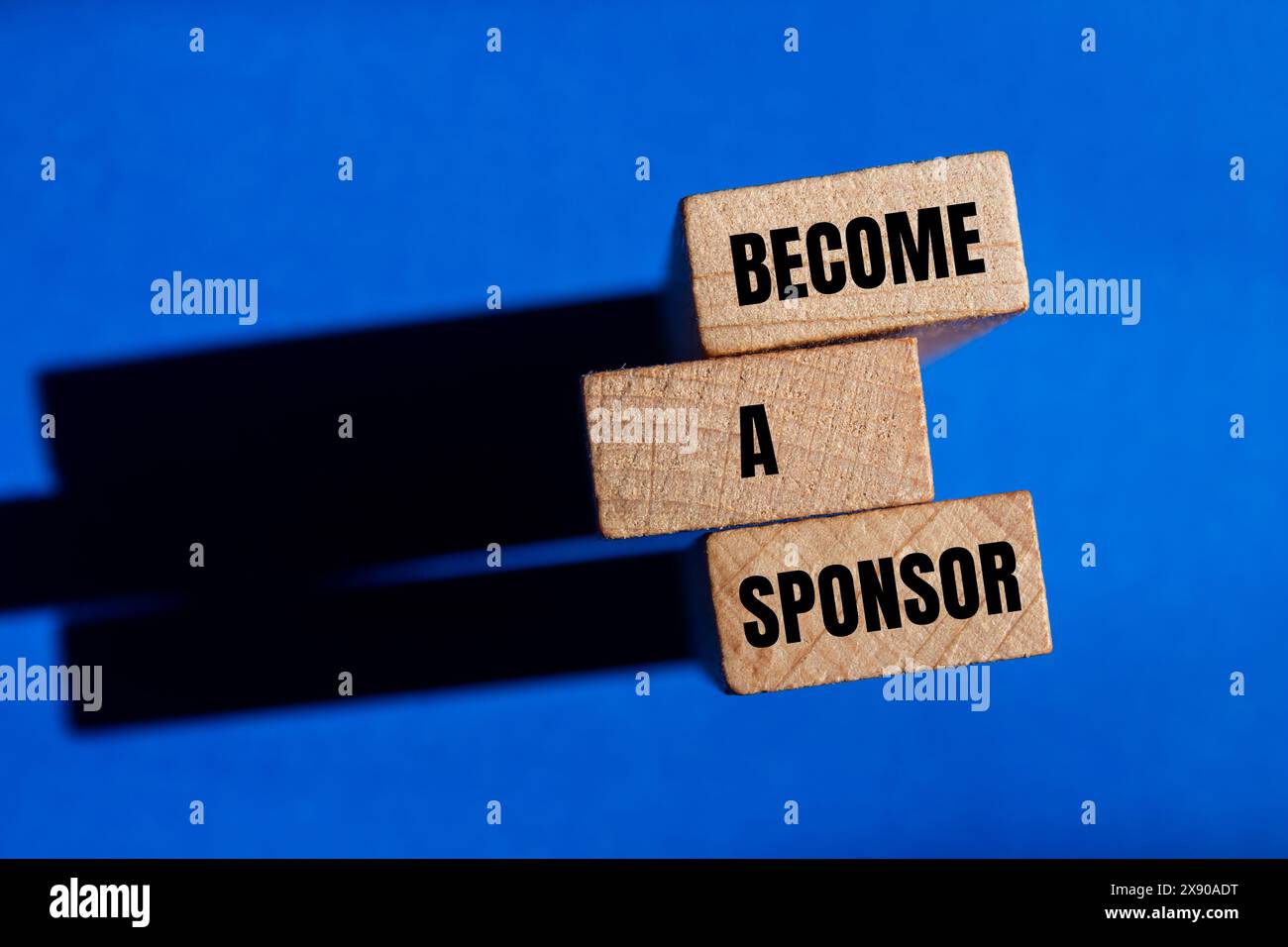 Become a sponsor words written on wooden blocks with blue background ...
