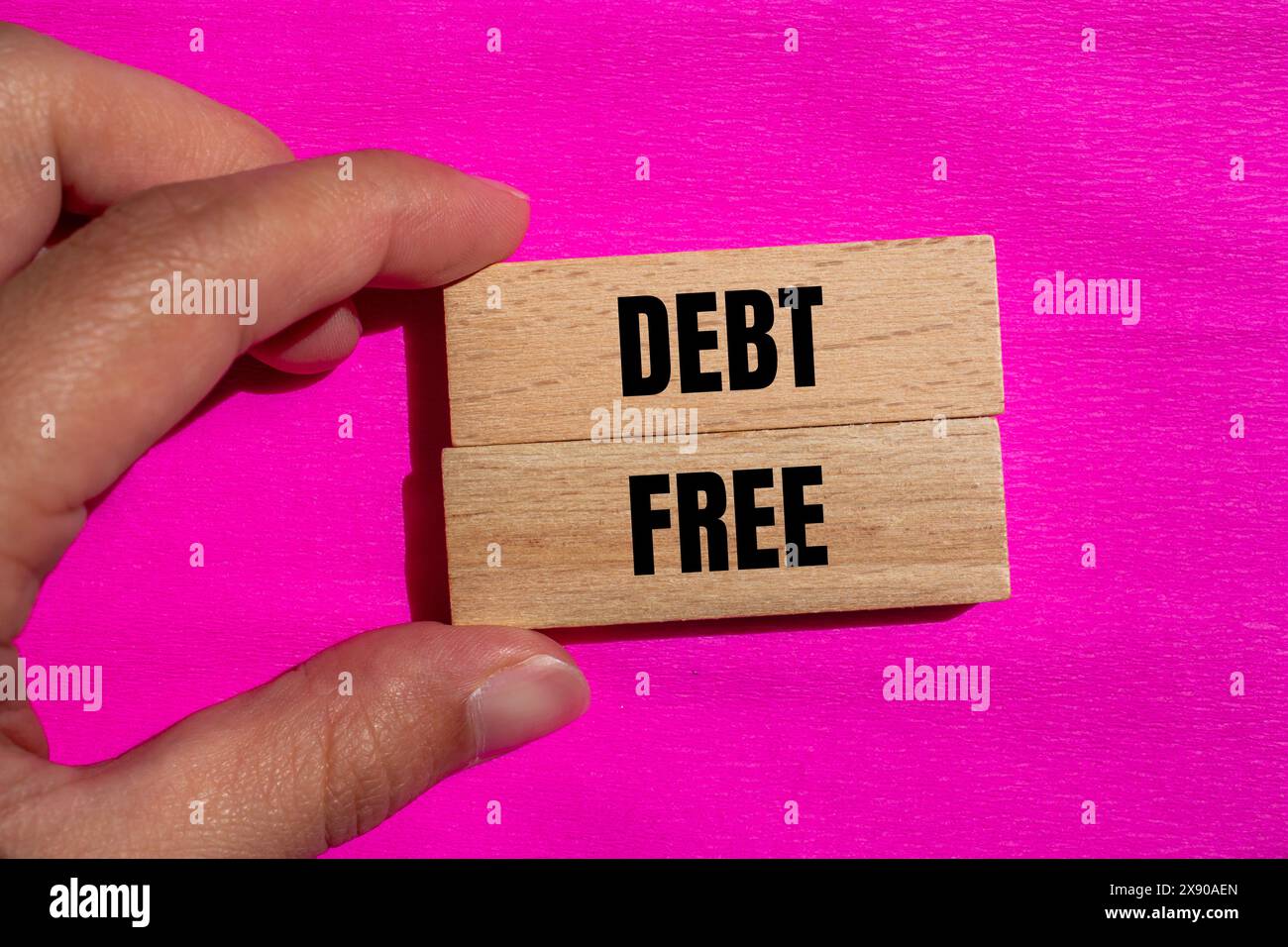 Debt free words written on wooden blocks with pink background ...