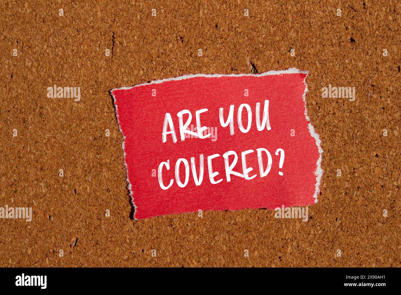 Are you covered ? words written on ripped red paper piece with brown ...