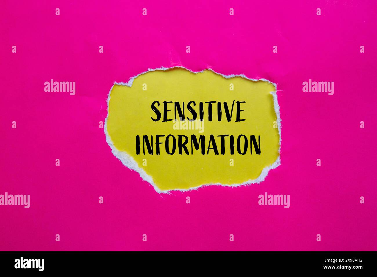 Sensitive information words written on ripped pink paper with yellow ...