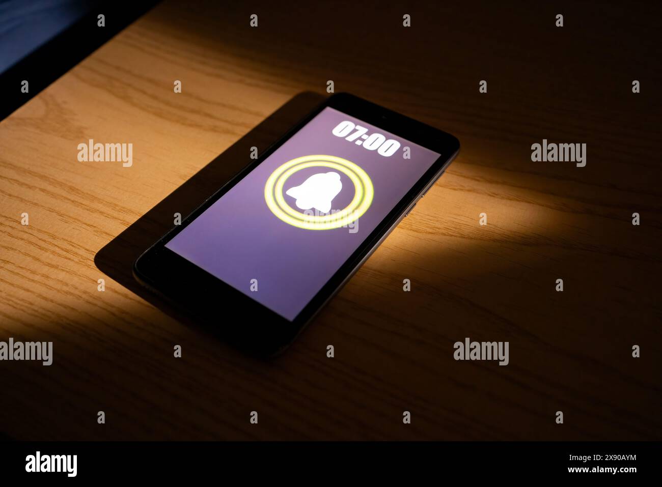 Smartphone alarm clock app rings for wake up, screen shows at bedroom ...