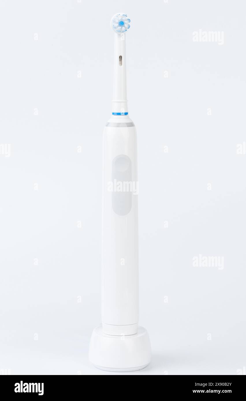 Electirc toothbrush on wireless charger stand isolated on white studio ...