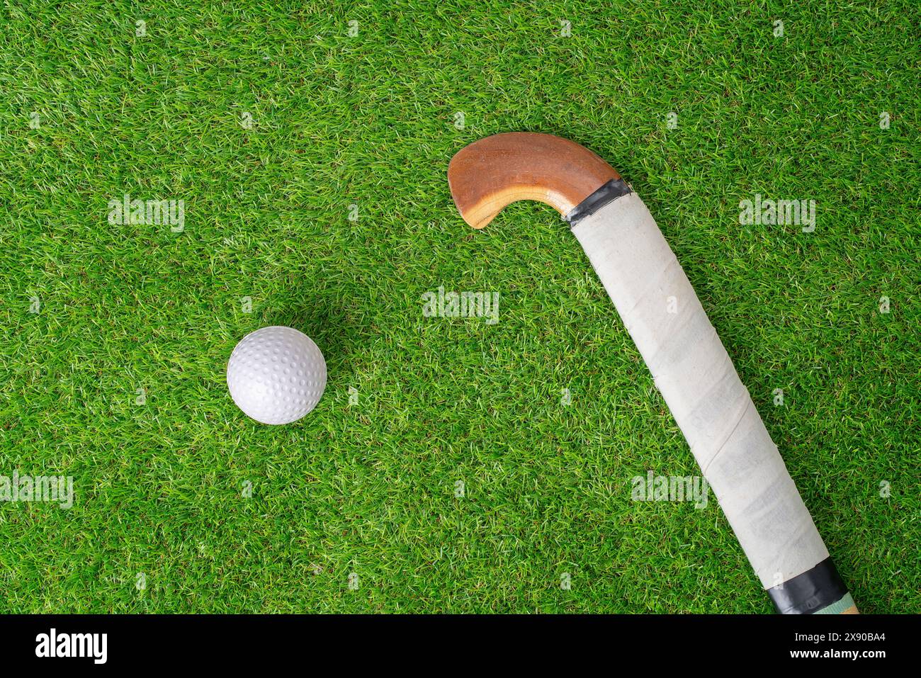 Hockey, ball and stick on green field, pitch and equipment against ...