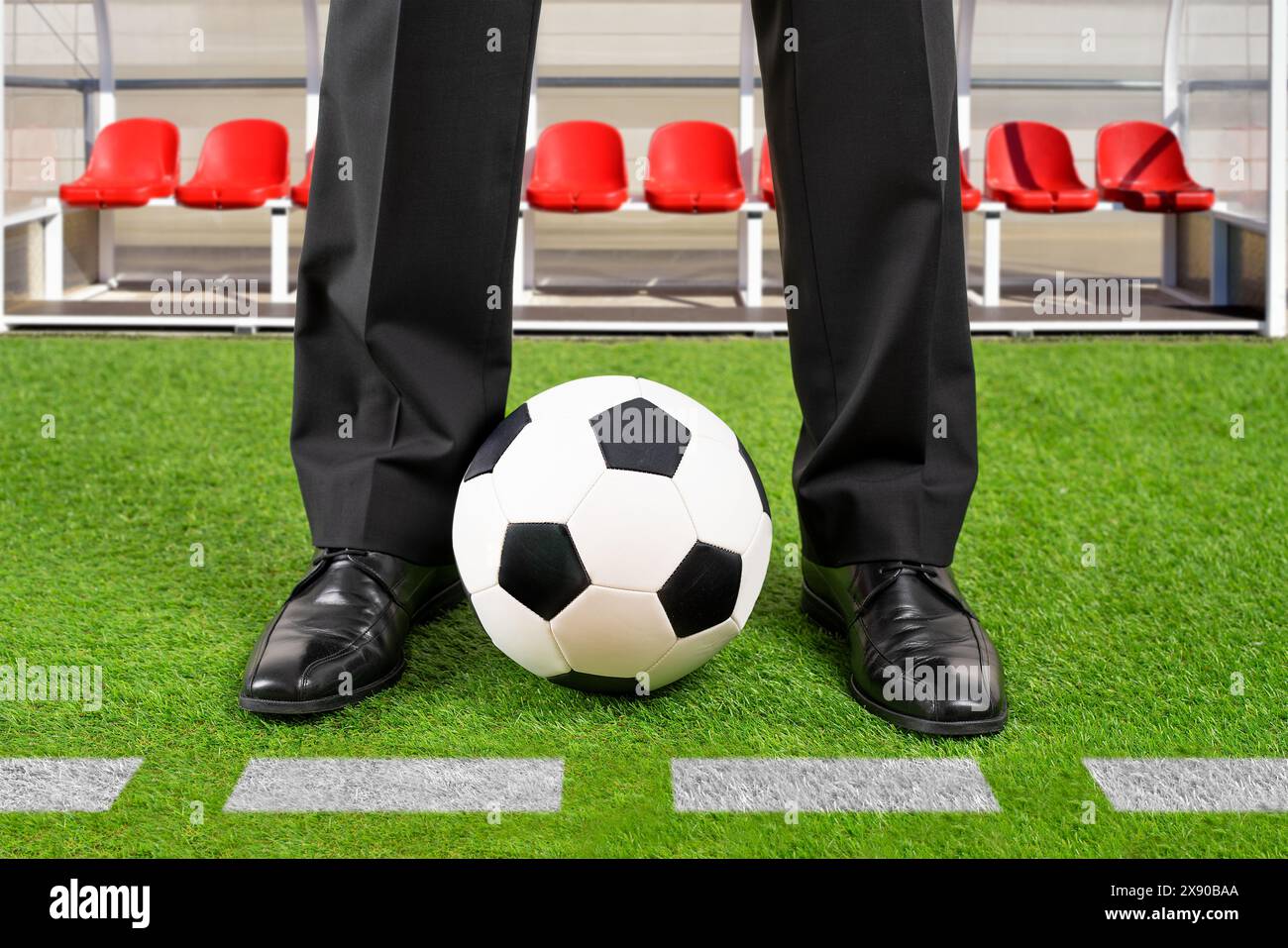 Close up of coach standing next to chalk line on soccer field with ball ...