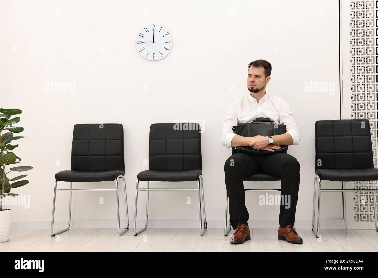 Man sitting on chair and waiting for job interview indoors Stock Photo ...