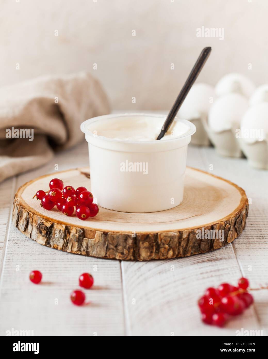 Natural sour cream in a plastic cup made from farm milk. Fermented milk ...