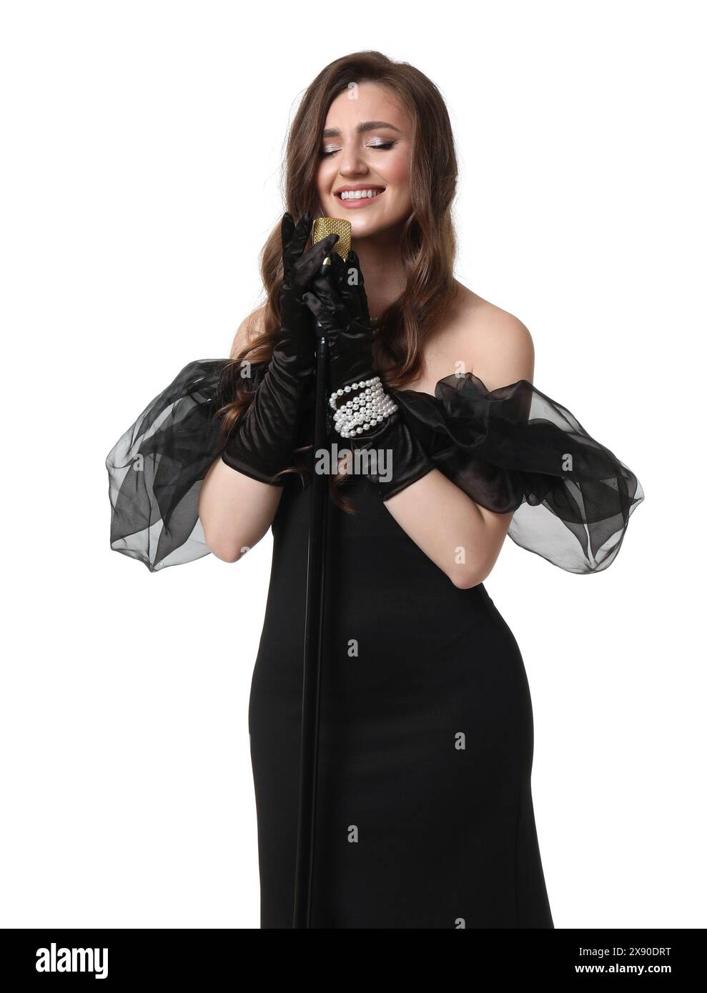 Beautiful young woman in stylish black dress with microphone singing on ...