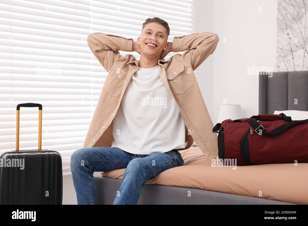 Smiling guest stretching in stylish hotel room Stock Photo - Alamy