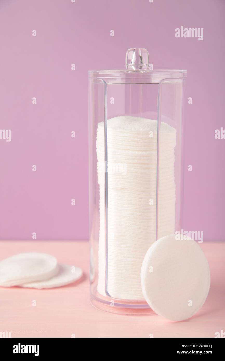 Cotton pads in containers on purple background. Top view Stock Photo ...