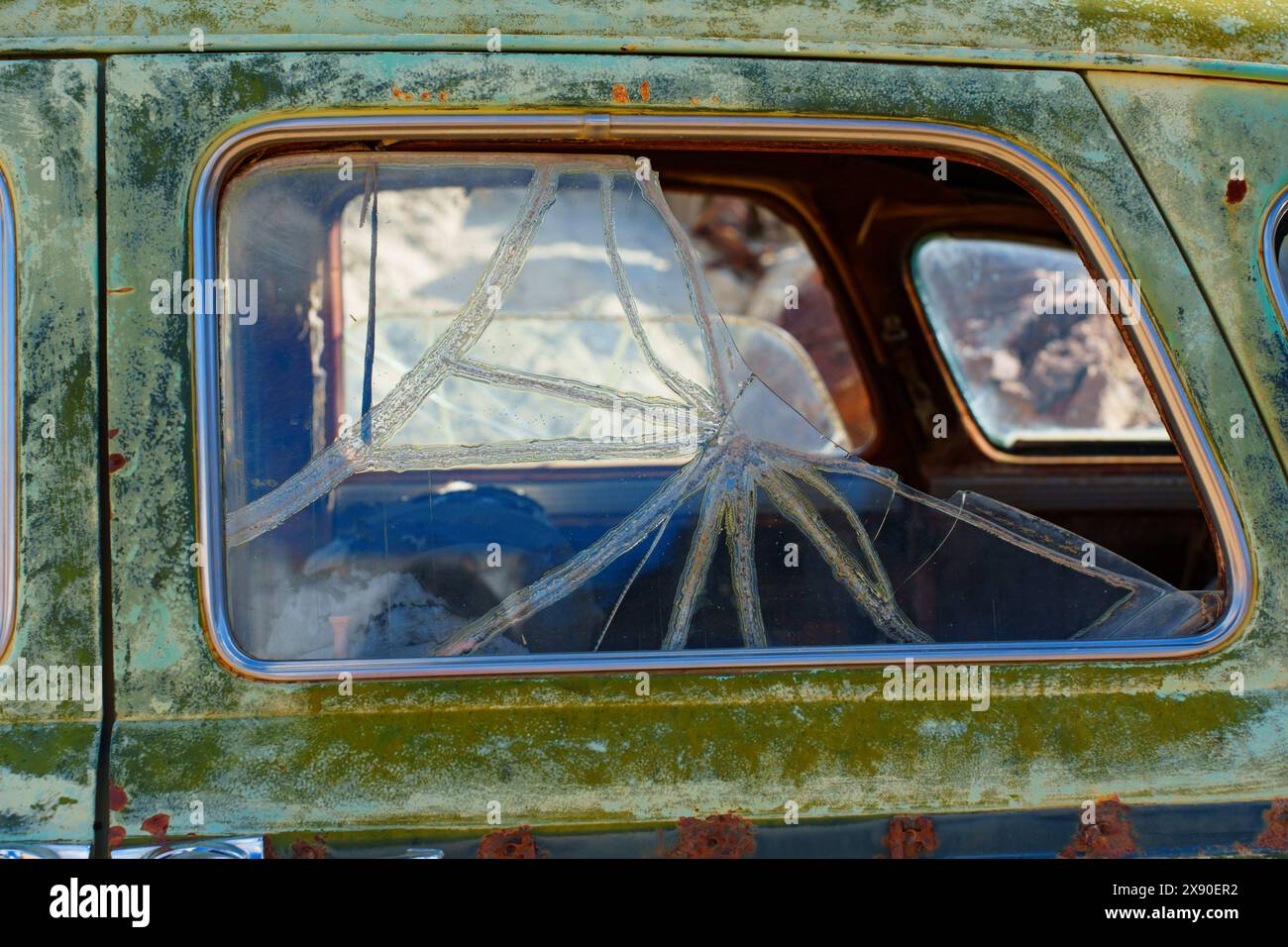 Close-up view of a broken side door window of a vintage care with some ...