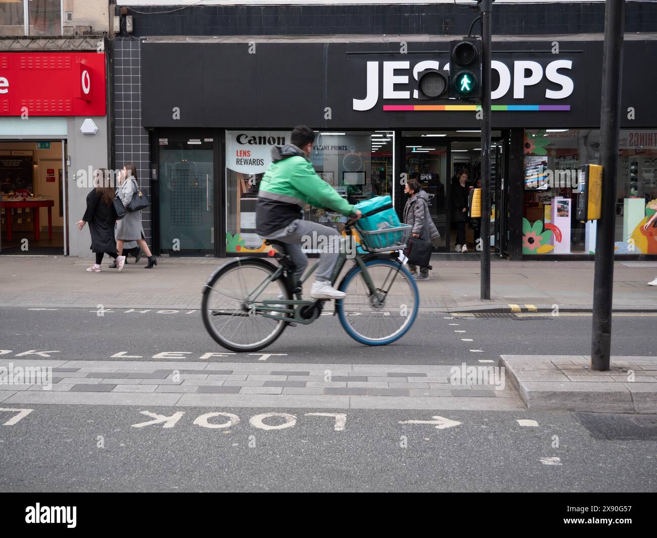 Deliveroo Food delivery e-bike riders jumping lights on Oxford street ...