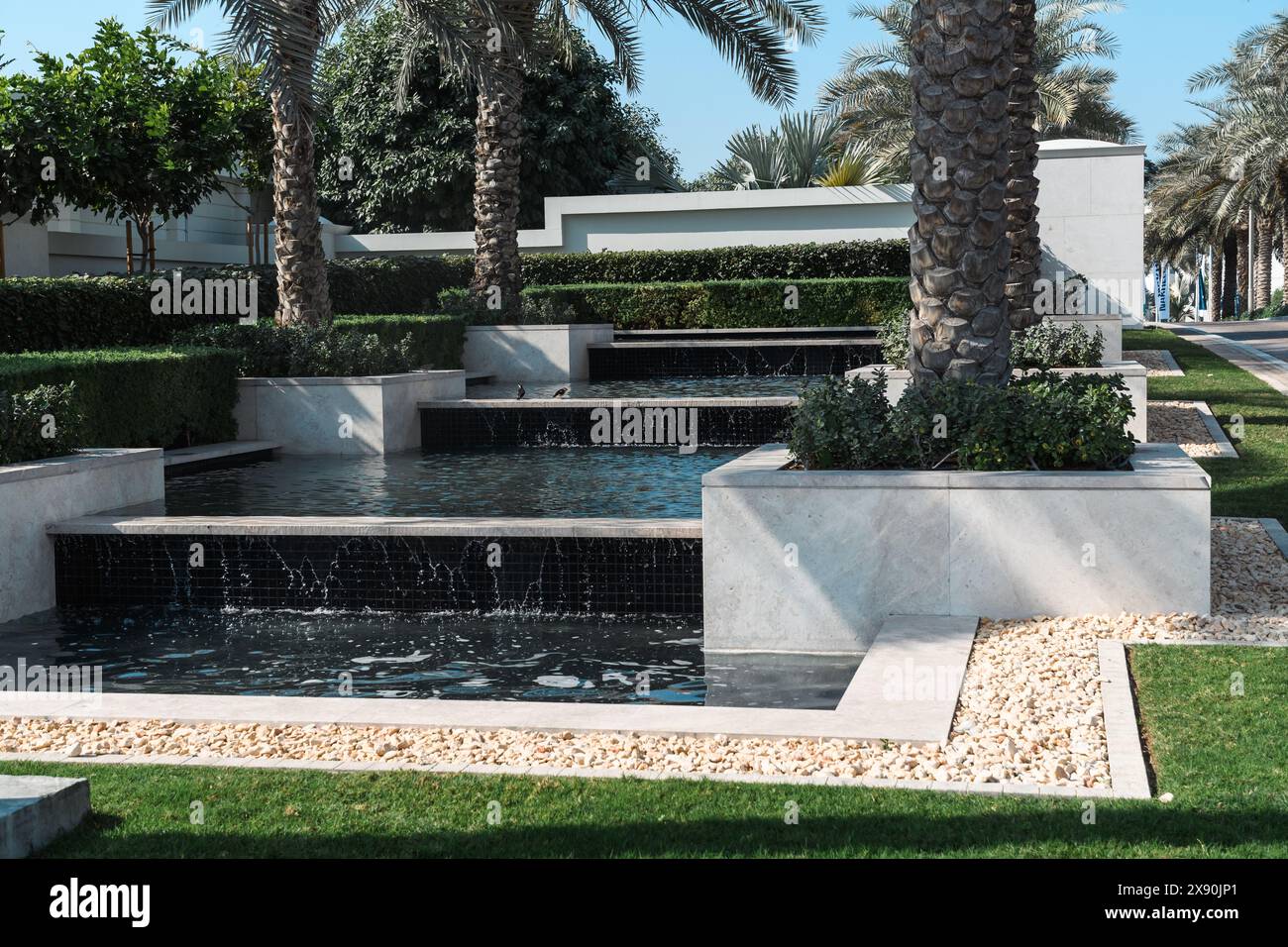 Dubai, UAE - January 6, 2024: Modern water feature amidst lush greenery ...