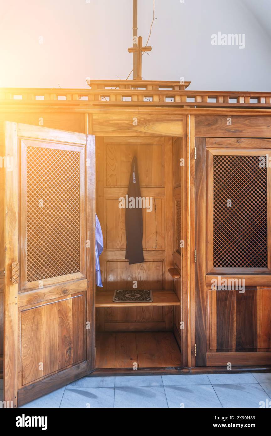 empty wooden confessional booth with open door inside the interior of ...