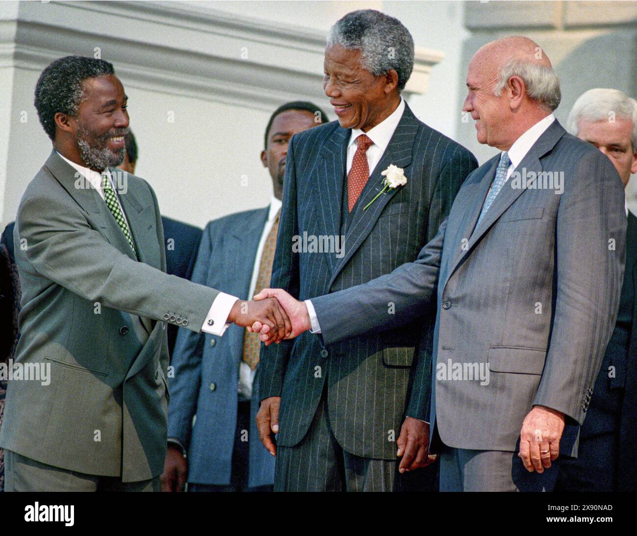 9 May 1994, Cape Town - South African President Nelson Mandela (C) shakes hands with his two ...