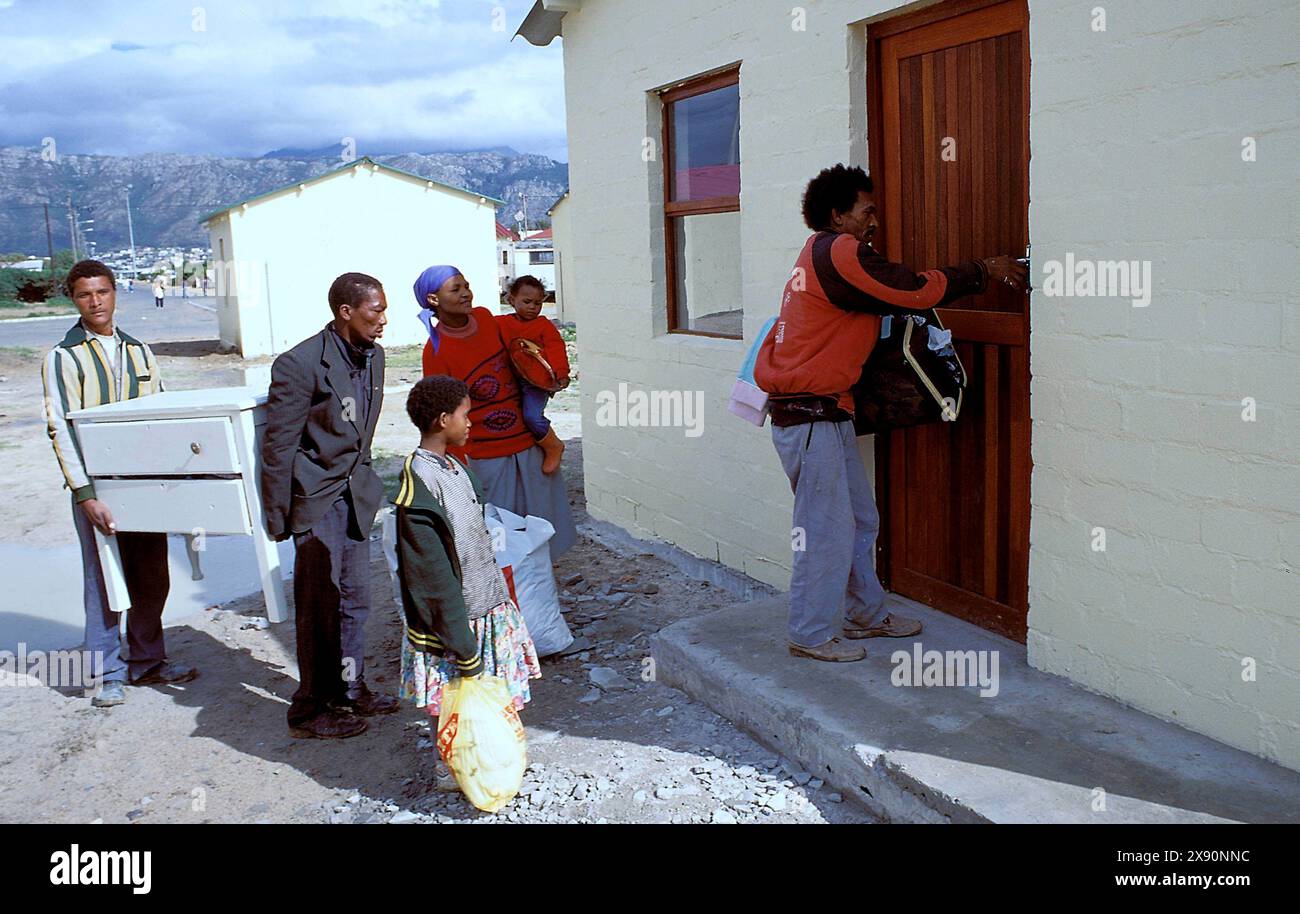 Strand housing project. Family in front of new RDP house. Man unlocking ...
