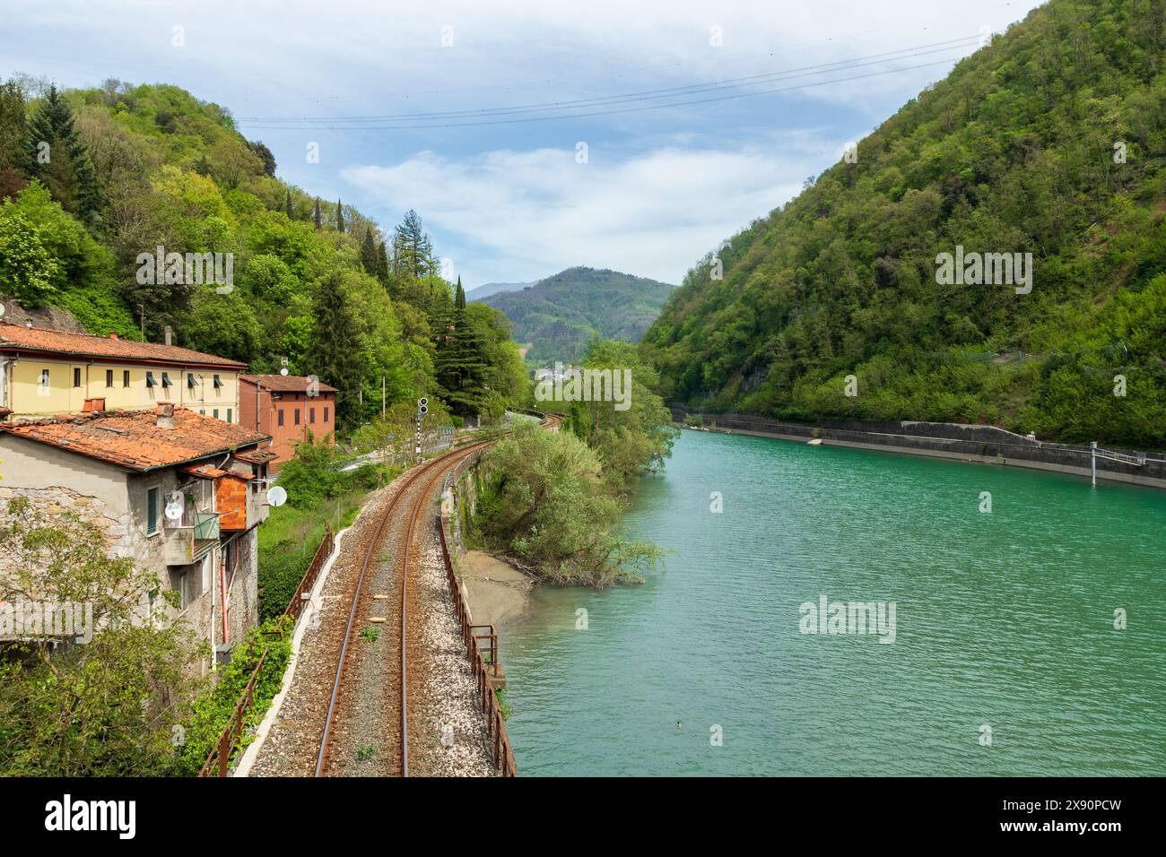 A single track railway line next to the Serchio River in Tuscany, Italy ...