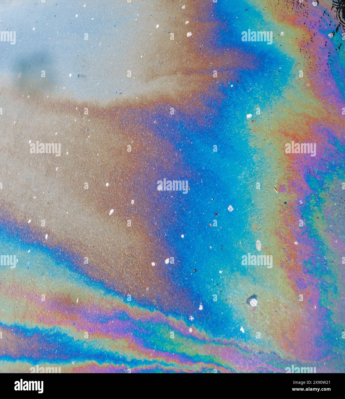 Rainbow colors of gasoline spill on asphalt Stock Photo - Alamy