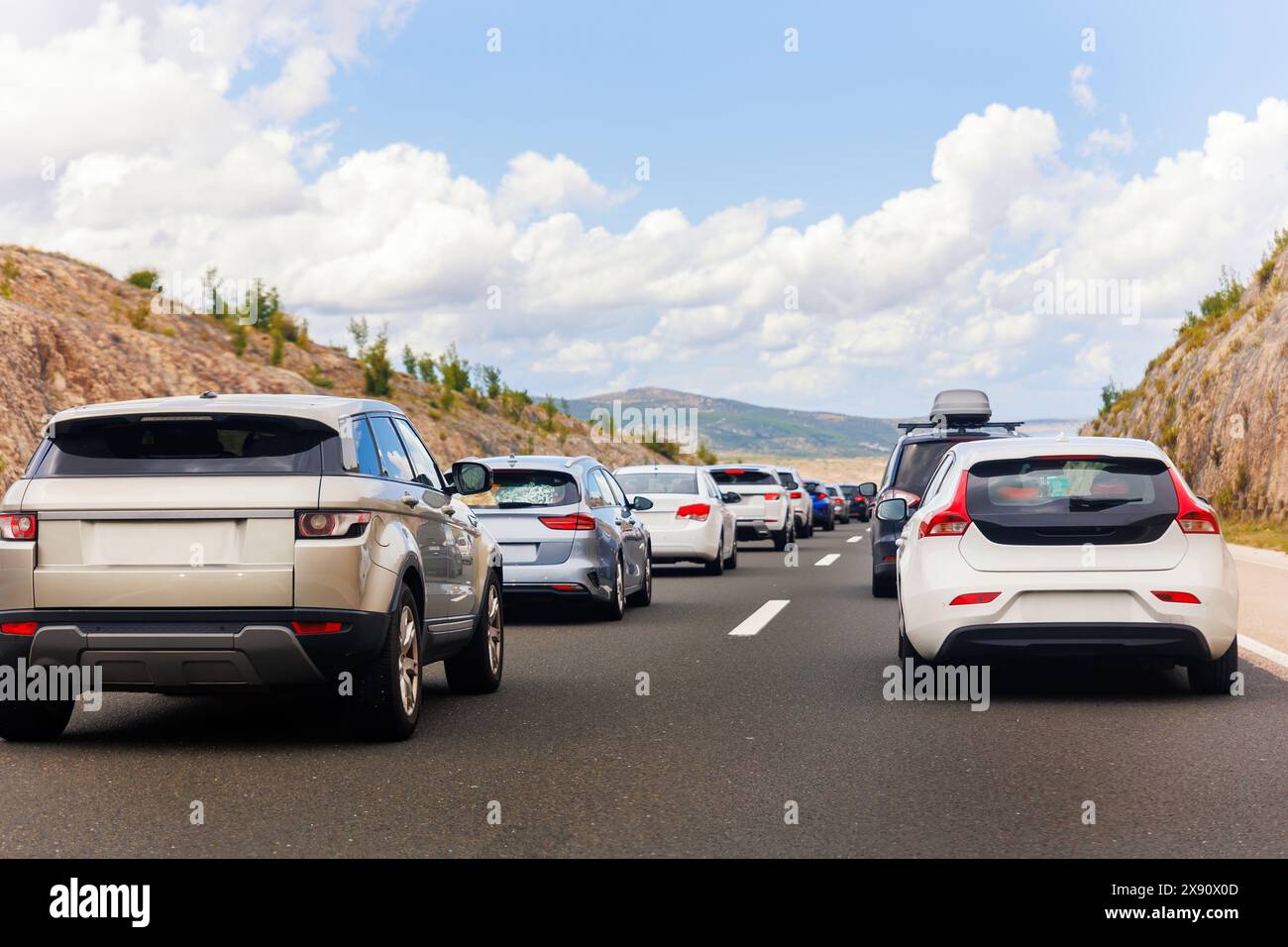Back tail view of many cars stuck in row at highway road traffic jam ...