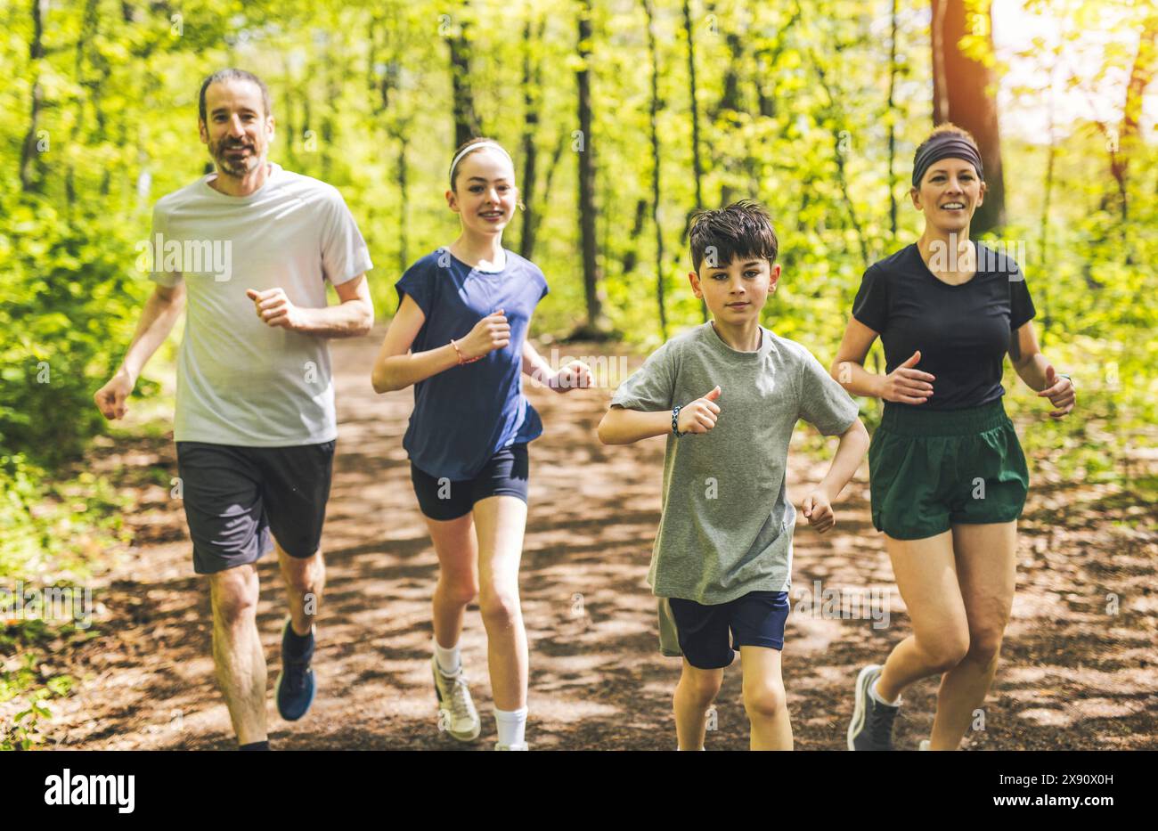 A Family exercising and jogging together at an outdoor park having ...